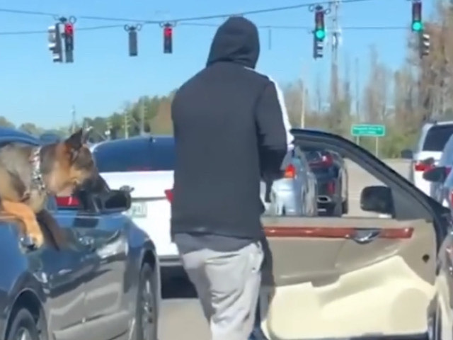 Man hops out of his car at traffic light and starts running toward car ...