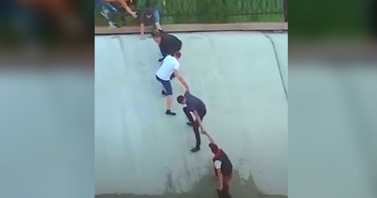 Onlookers form incredible human chain to save dog trapped in reservoir