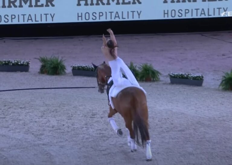 Woman stands on horse then proceeds to do a back flip mid ride